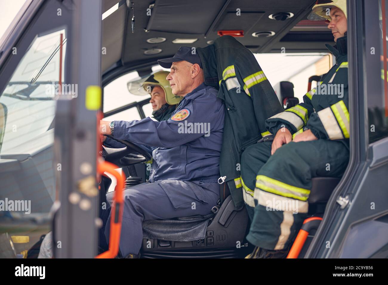 Portrait of adult males sitting on the big truck with driver Stock ...