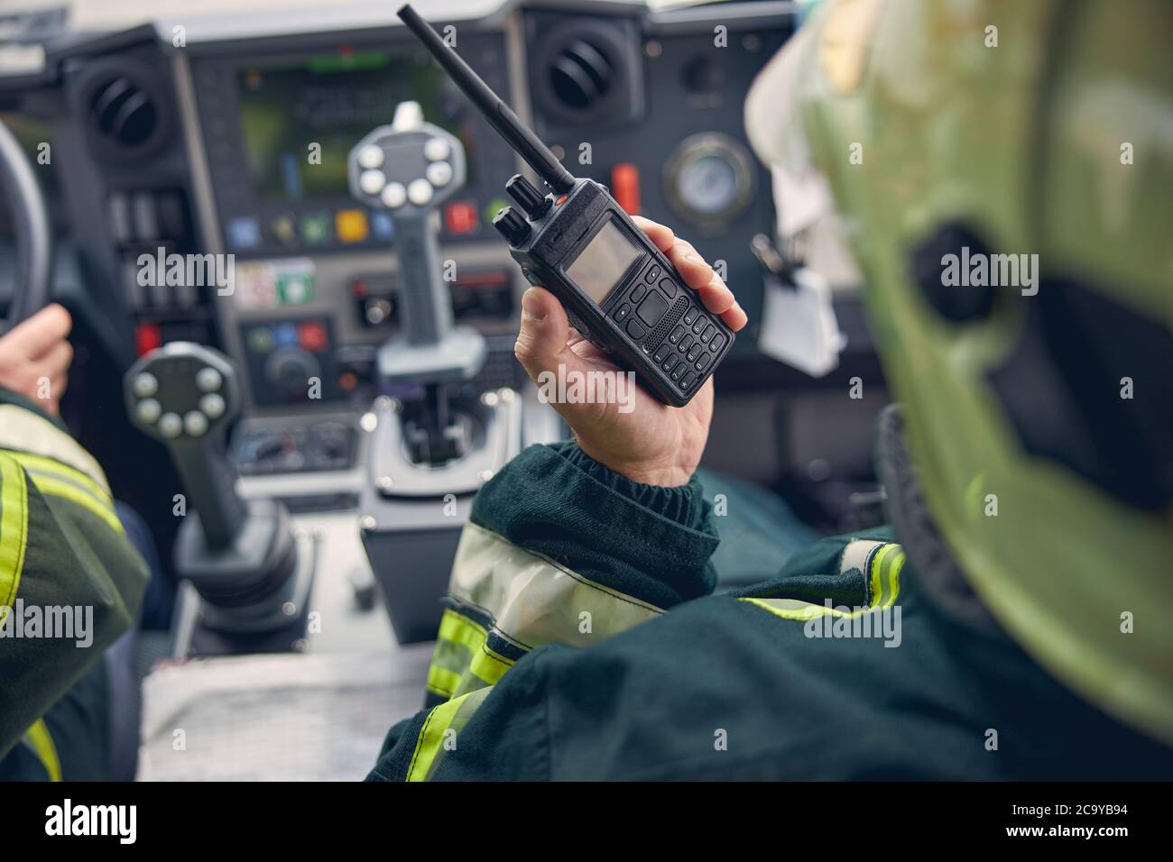 Firefighter holding walkie talkie at fire machine Stock Photo - Alamy