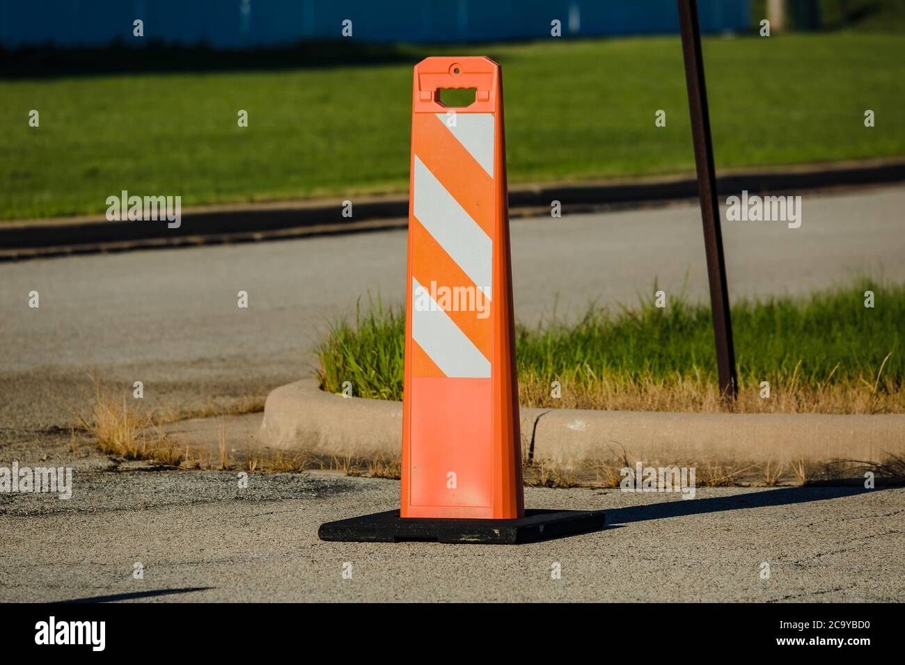 one traffic cone guarding the entrance to a parking lot Stock Photo - Alamy