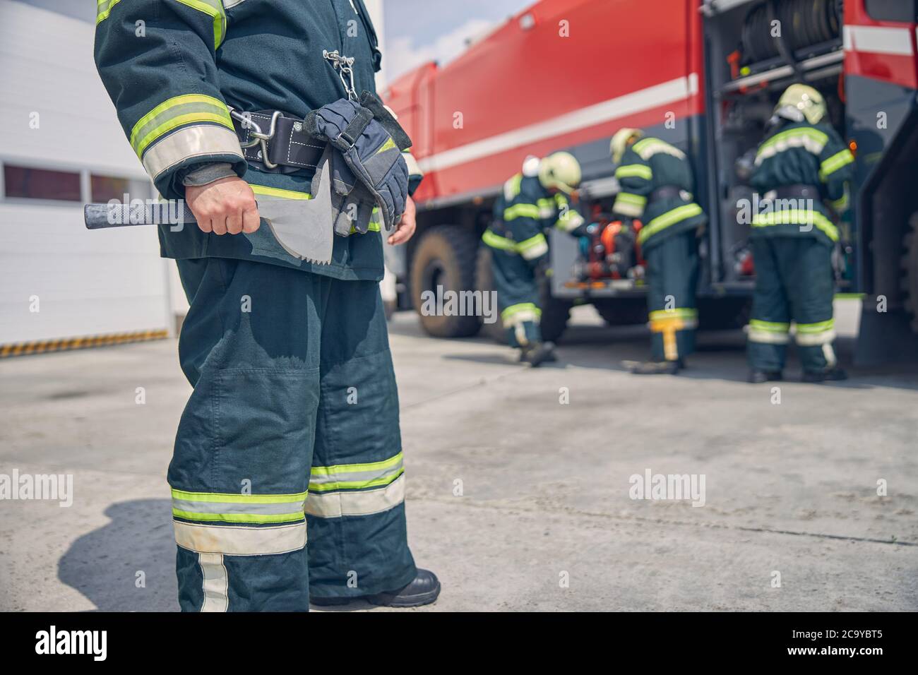 Portrait of strong male wearing green work uniform with gloves on the ...