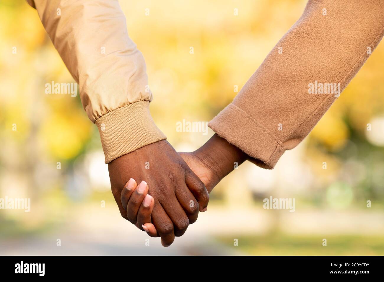 Romantic african american couple holding hands outdoors, closeup Stock ...