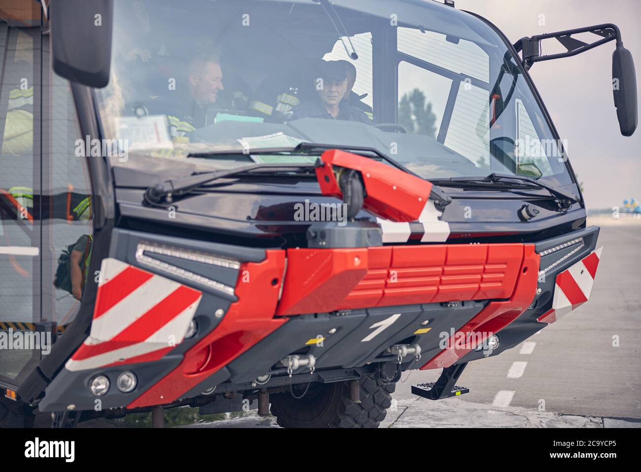 Rescue team sitting in the red fire engine Stock Photo - Alamy