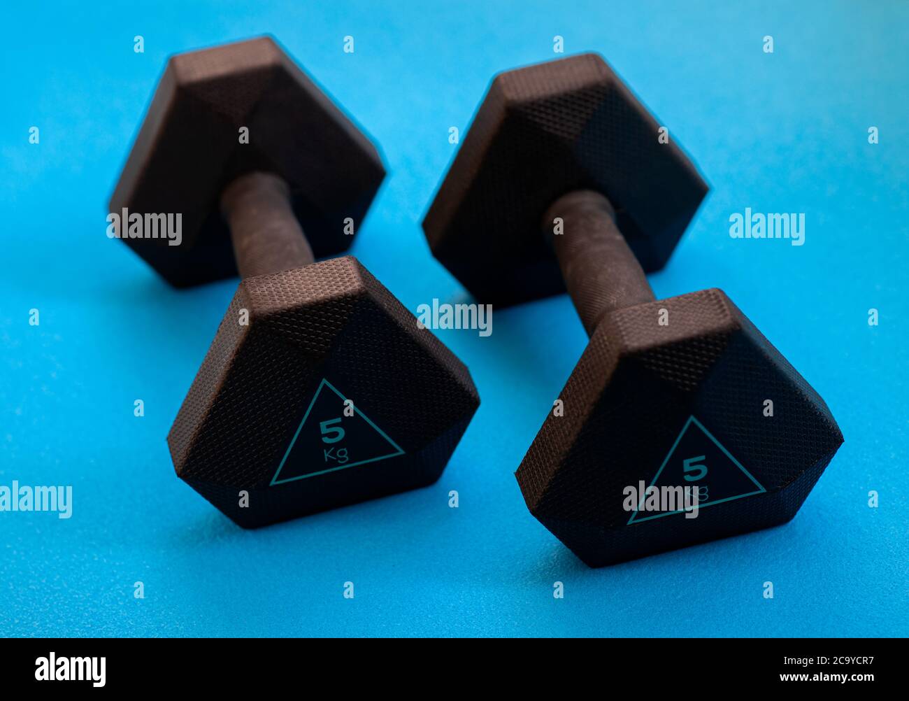 Two black weights 5 kg on the blue background Stock Photo - Alamy