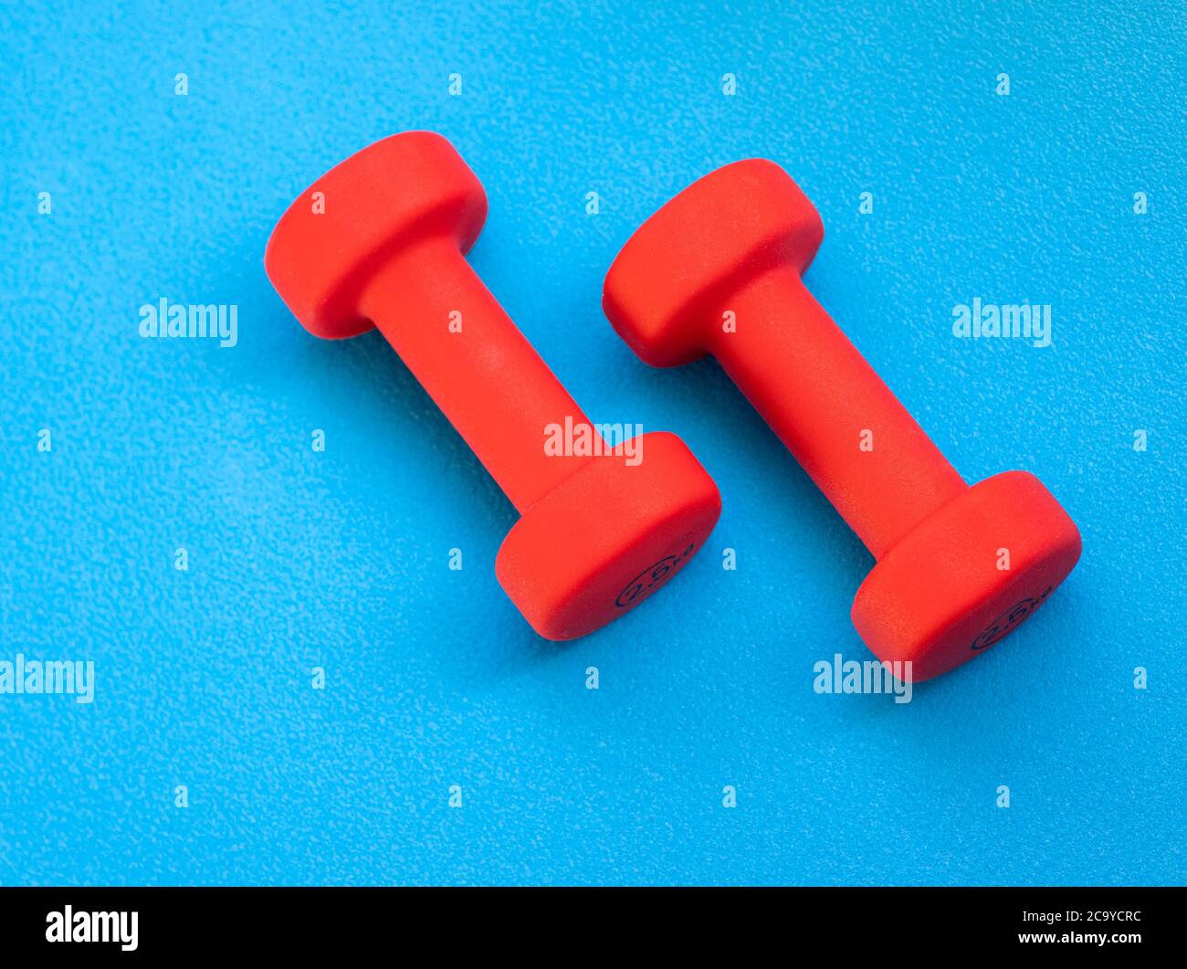 Two red weights on the blue background Stock Photo - Alamy