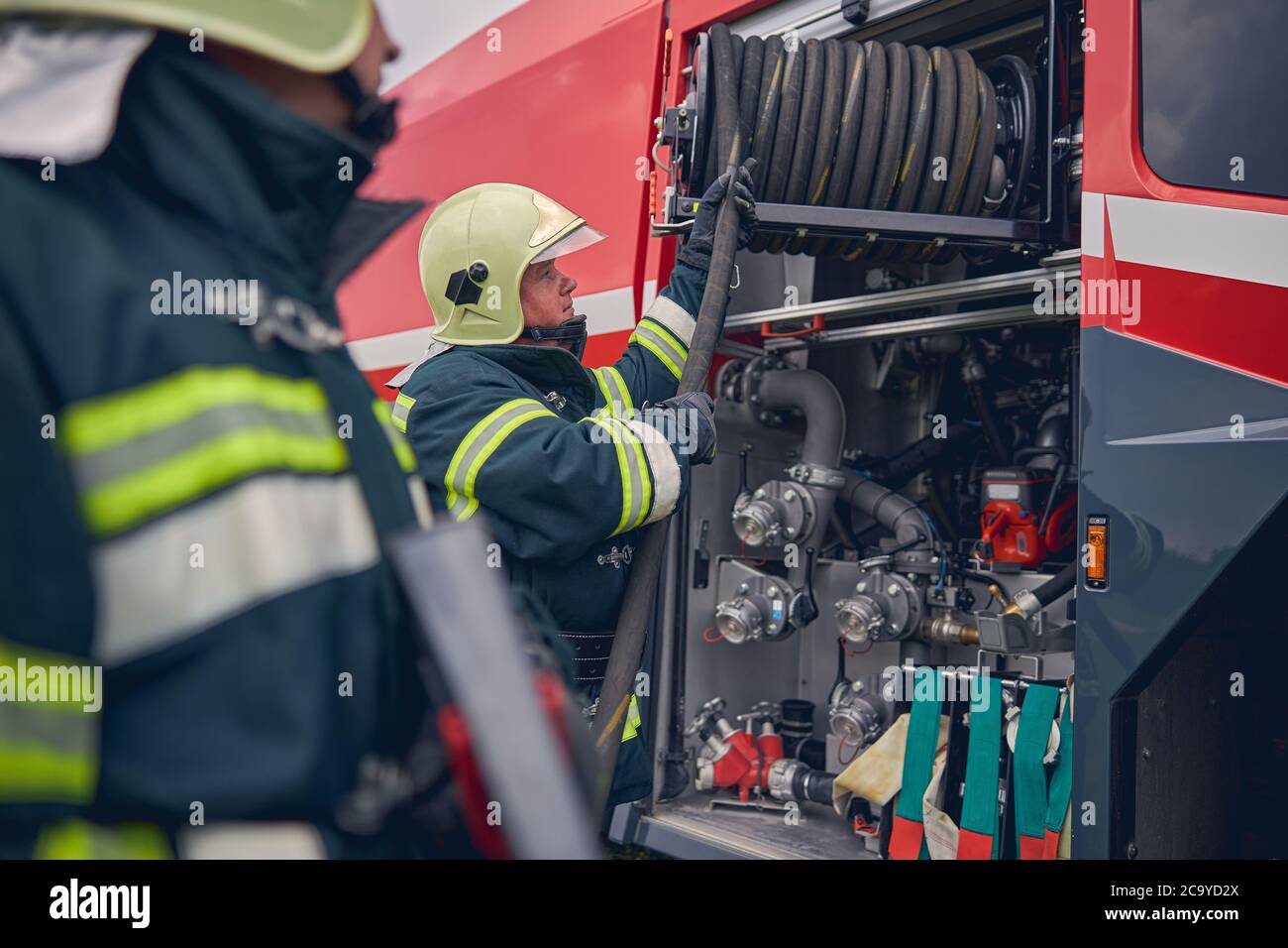 Fireman wearing safe helmet standing next to the fire engine Stock ...