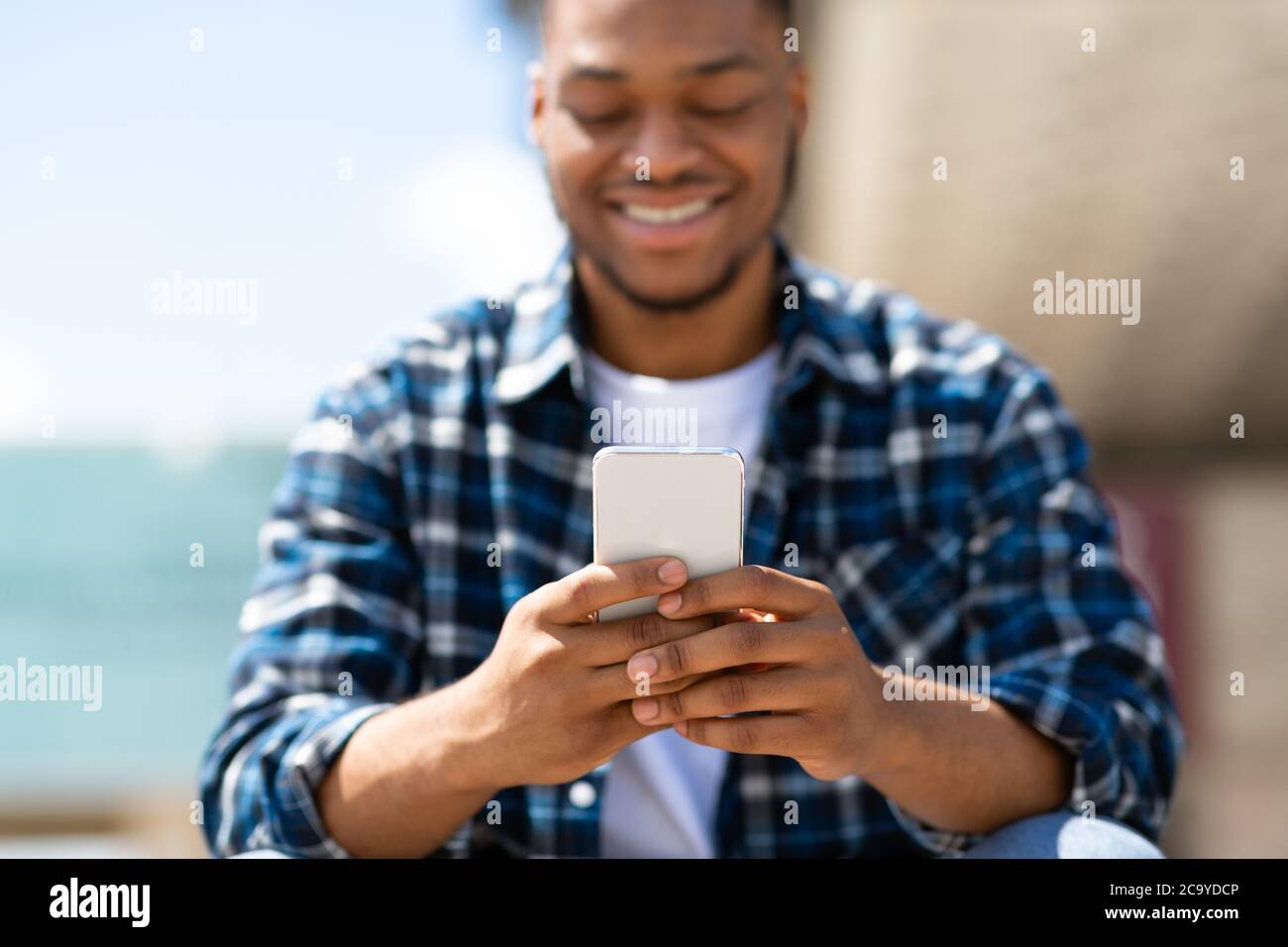 Portrait of african american guy texting sms on smartphone Stock Photo ...