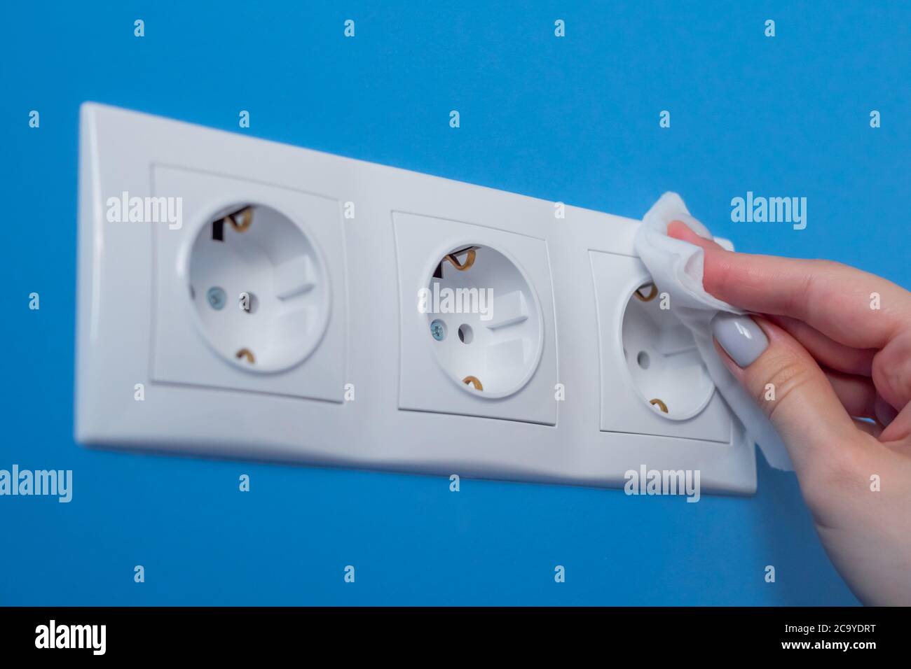 Woman cleaning electrical european outlet, socket with disinfectant wet ...