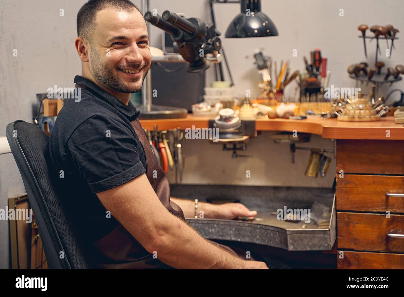 Joyous bearded craftsman smiling at the camera Stock Photo - Alamy