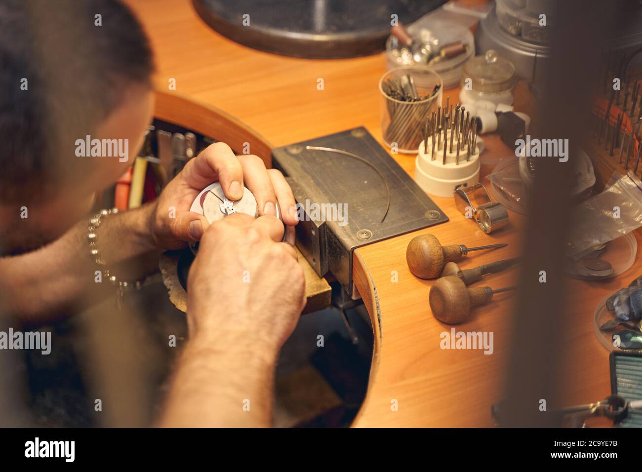 Man leaning over the engraving block ball vise Stock Photo - Alamy