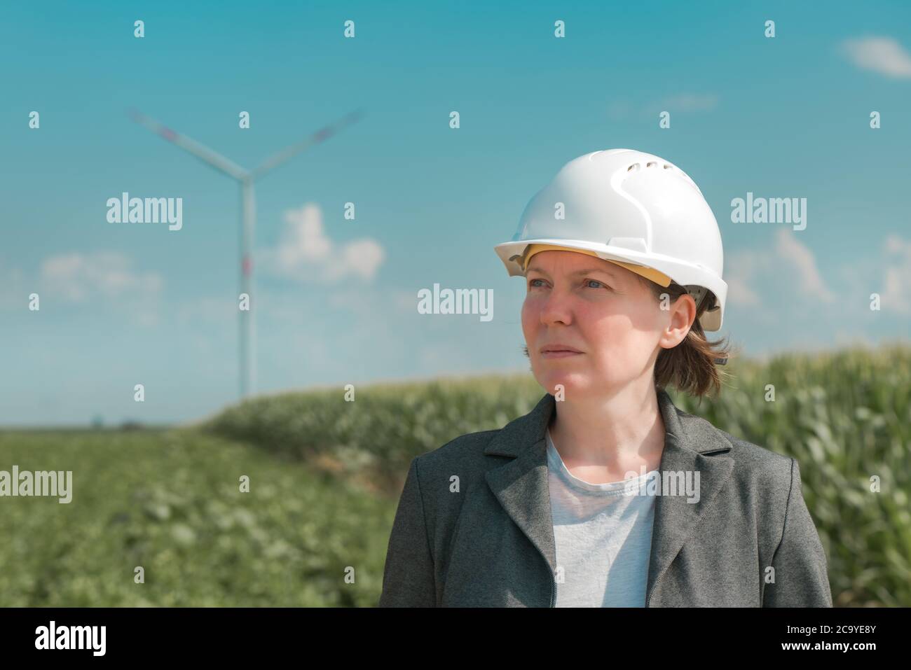Portrait of female engineer on modern wind turbine farm during ...