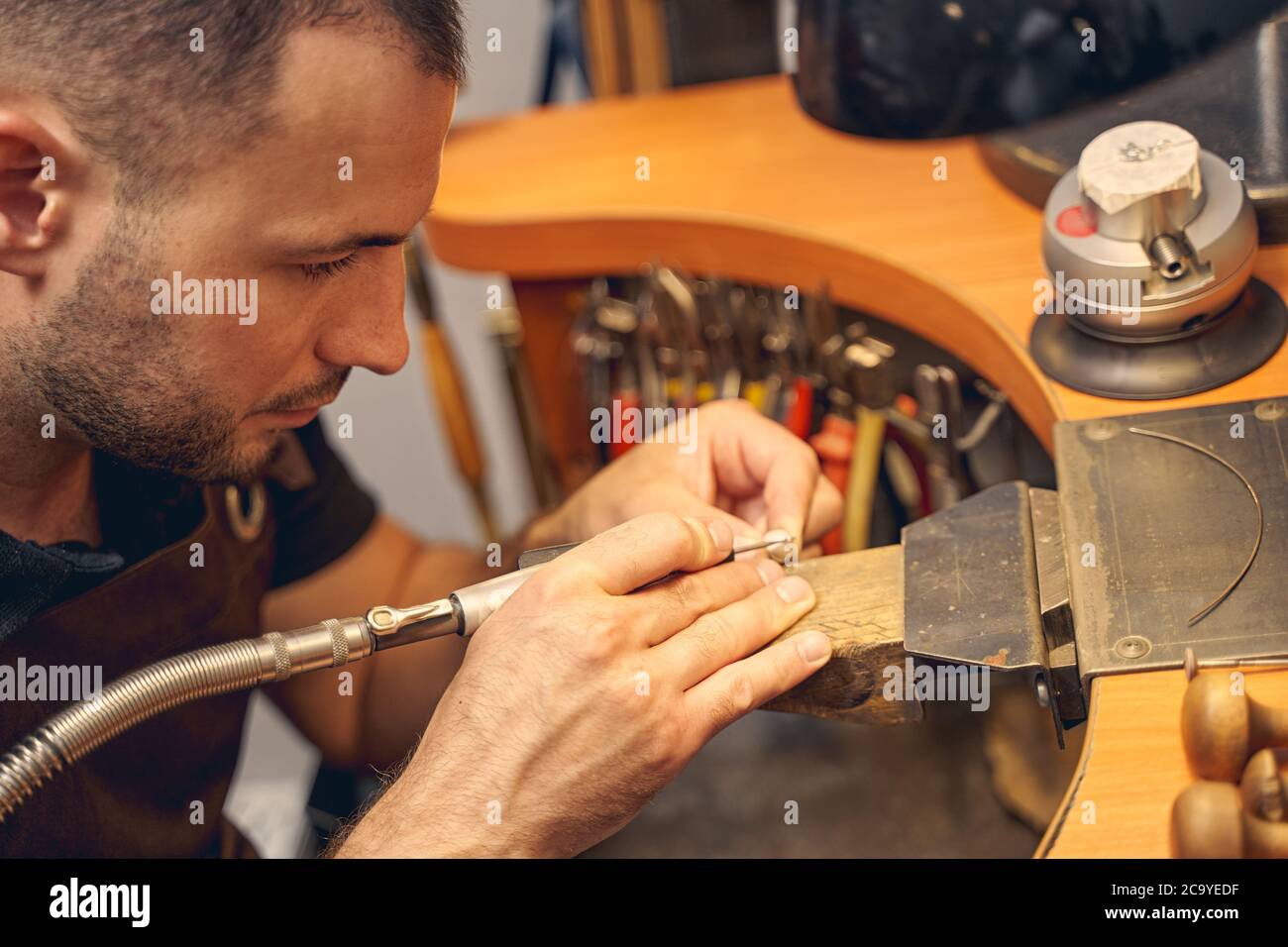 Male jeweler working with a hand tool Stock Photo - Alamy