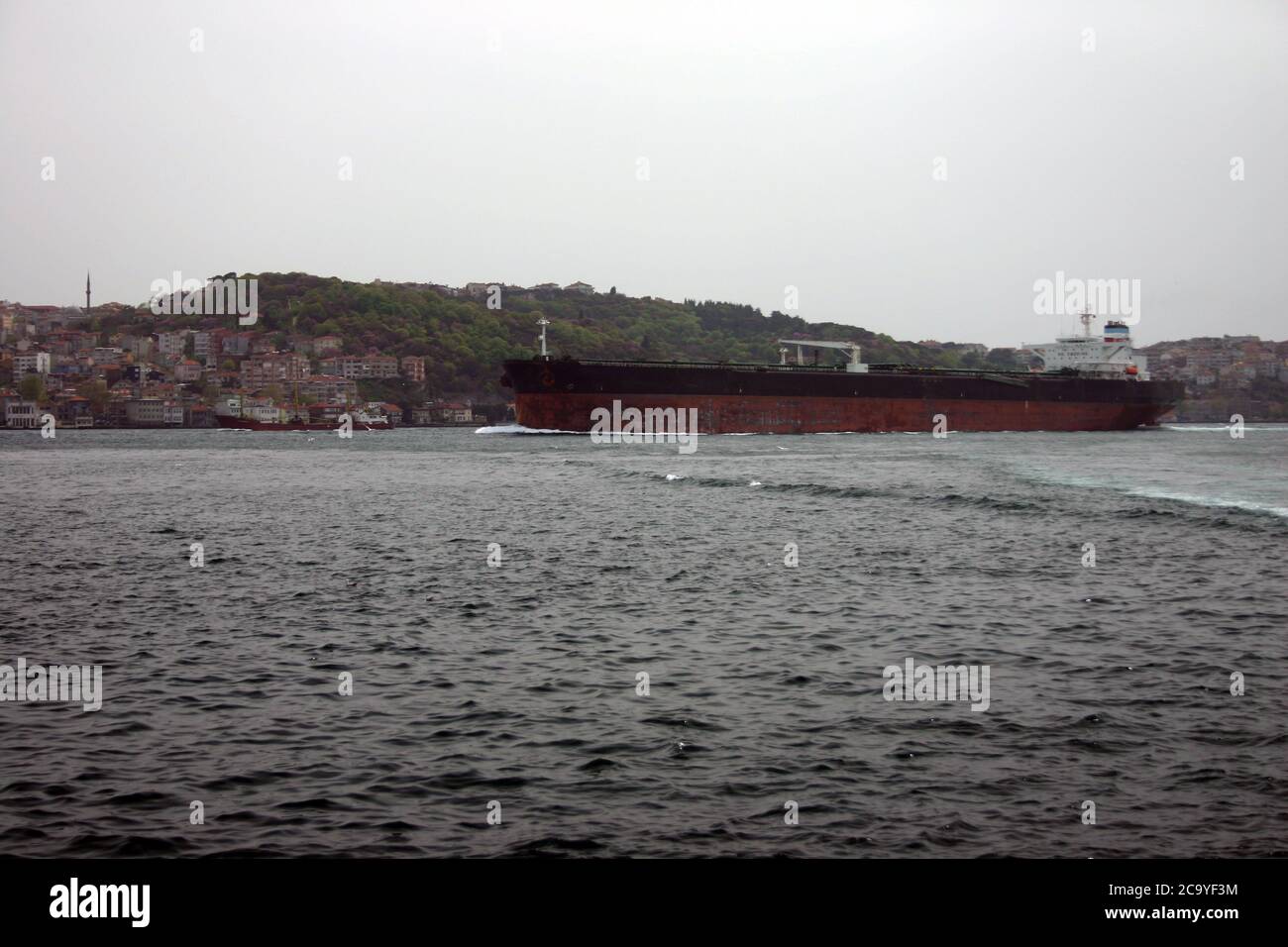 A big oil tanker passing under the bridge in the Bosphorus. The ...