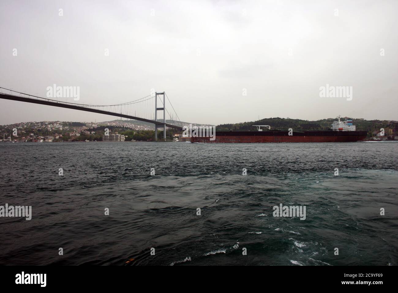 A big oil tanker passing under the bridge in the Bosphorus. The ...