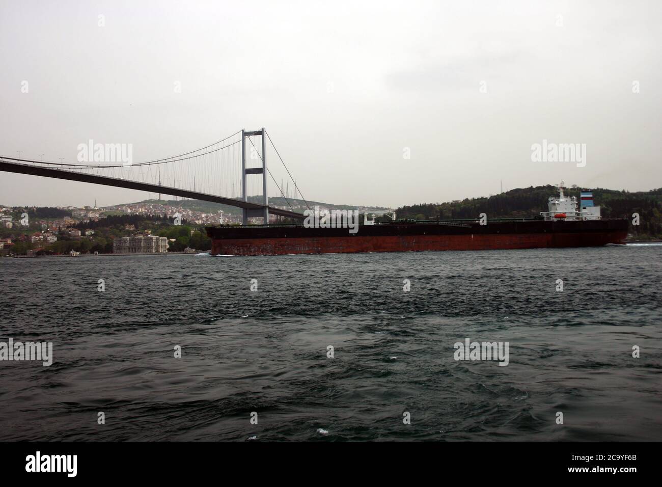 A big oil tanker passing under the bridge in the Bosphorus. The ...
