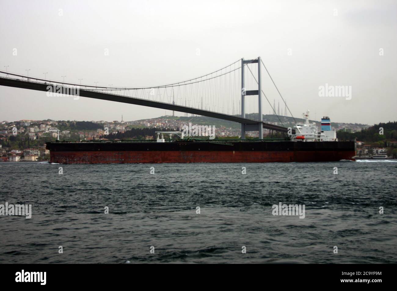 A big oil tanker passing under the bridge in the Bosphorus. The ...