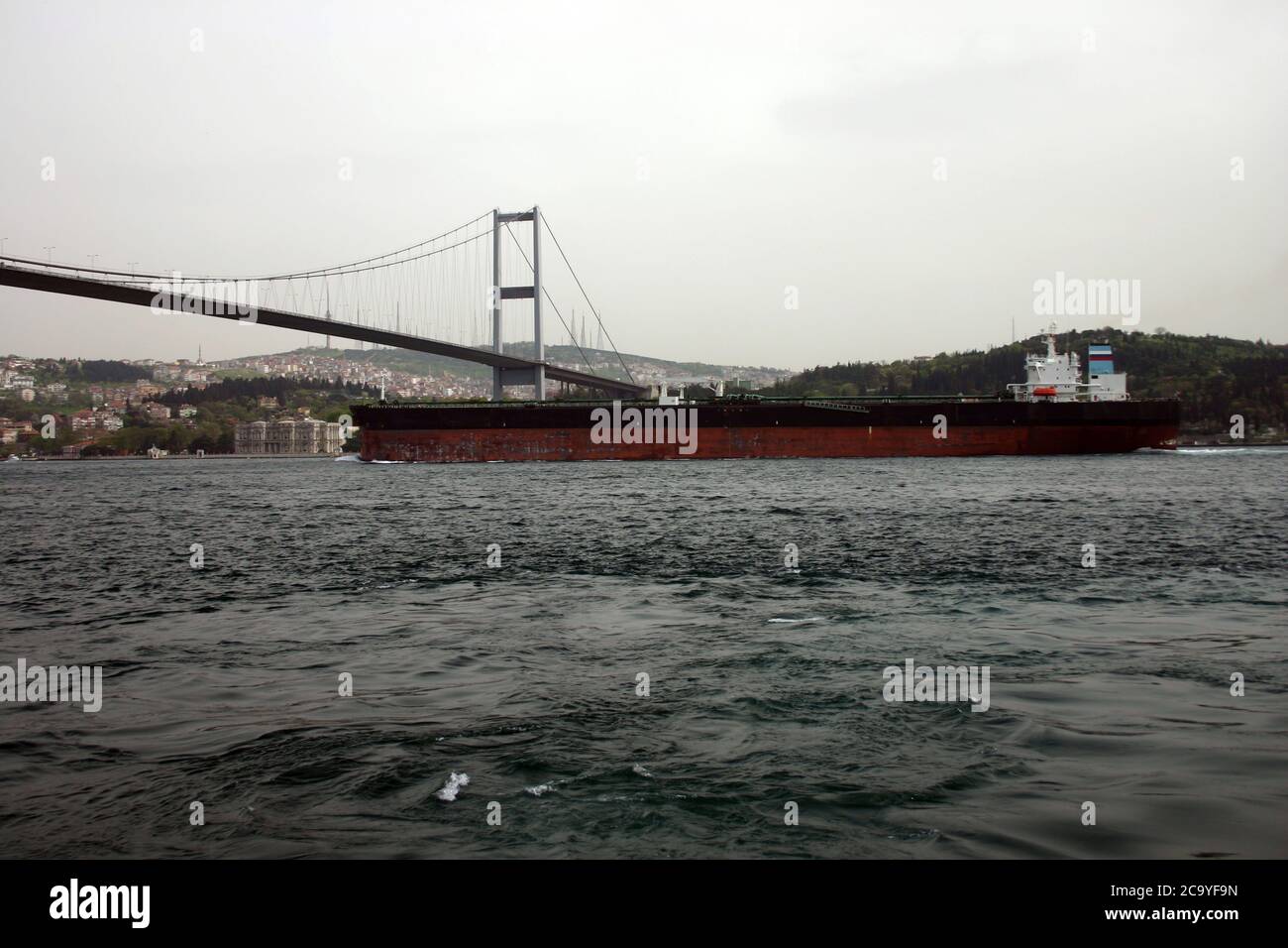 A big oil tanker passing under the bridge in the Bosphorus. The ...