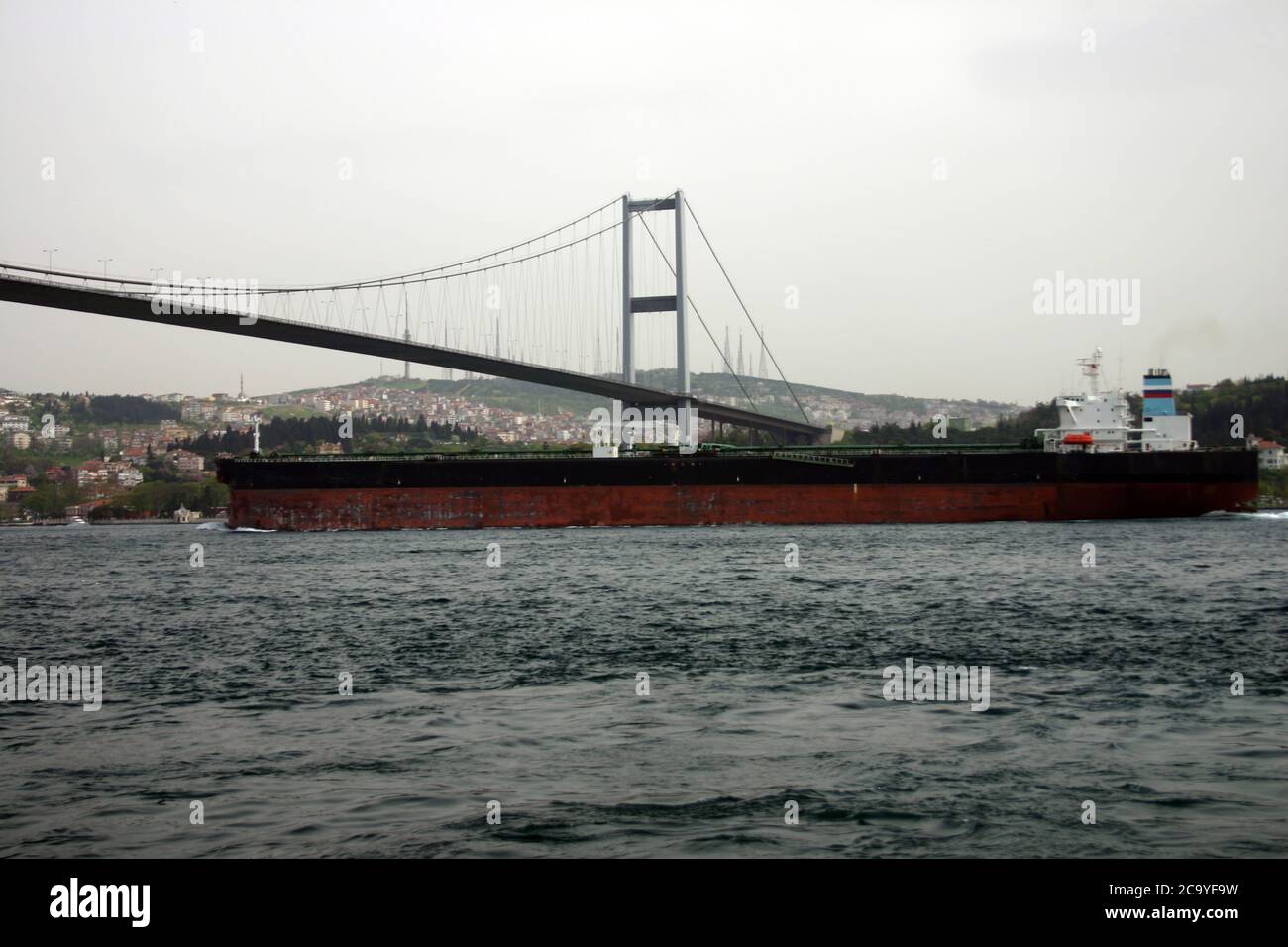 A big oil tanker passing under the bridge in the Bosphorus. The ...