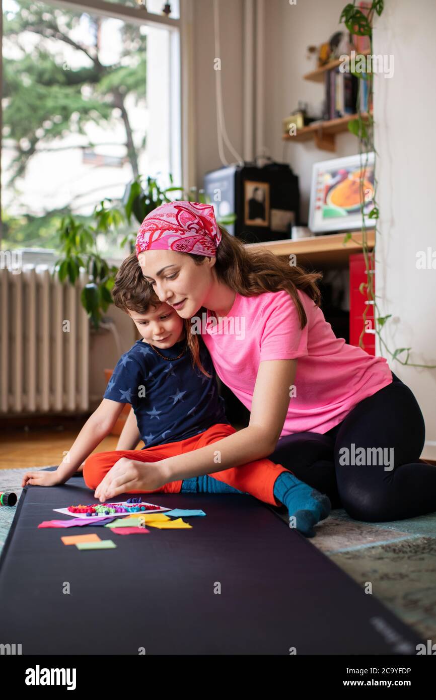 Young Mother and Child Making Paper Handicrafts Together at Home Stock ...