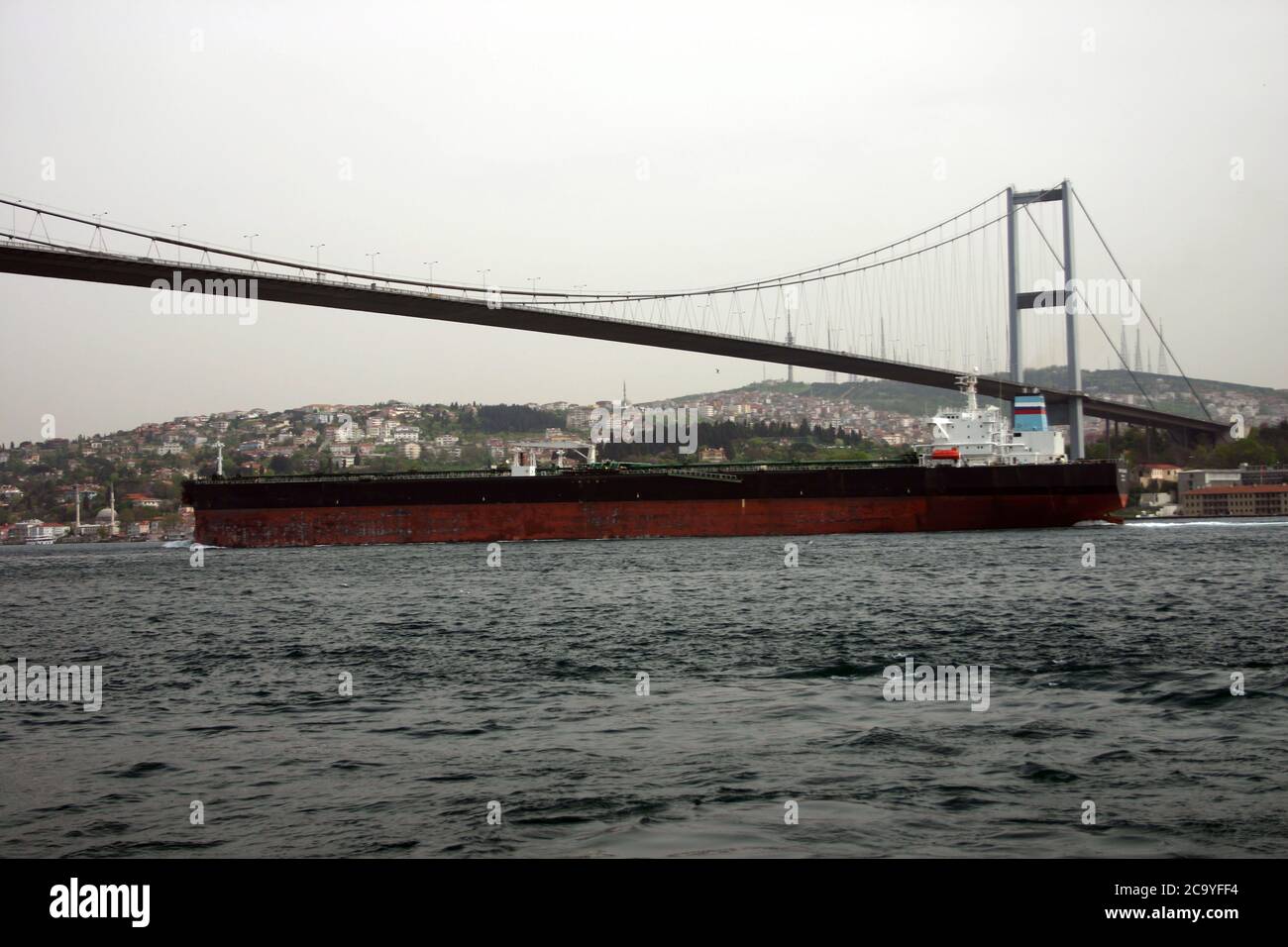 A big oil tanker passing under the bridge in the Bosphorus. The ...
