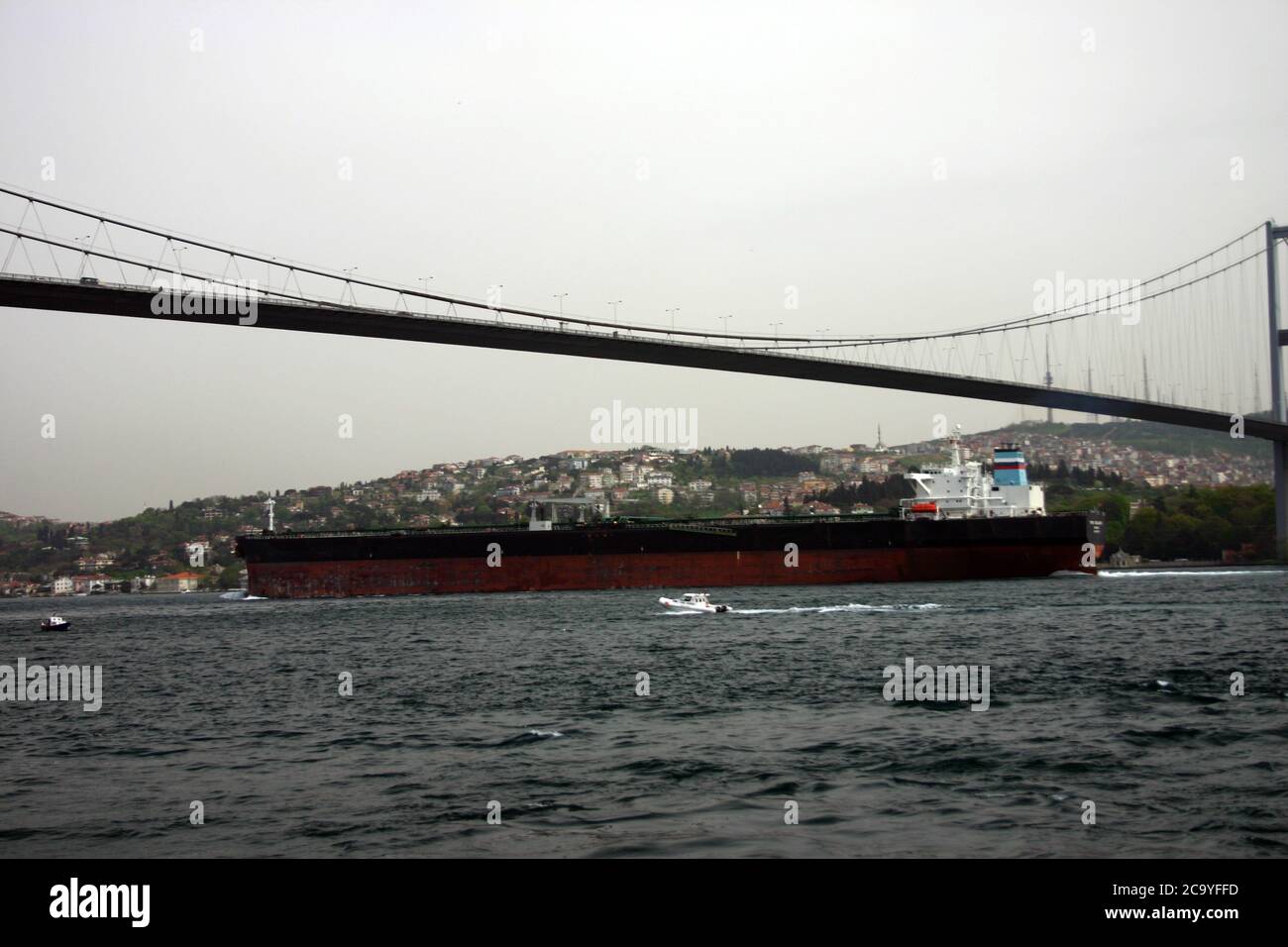 A big oil tanker passing under the bridge in the Bosphorus. The ...