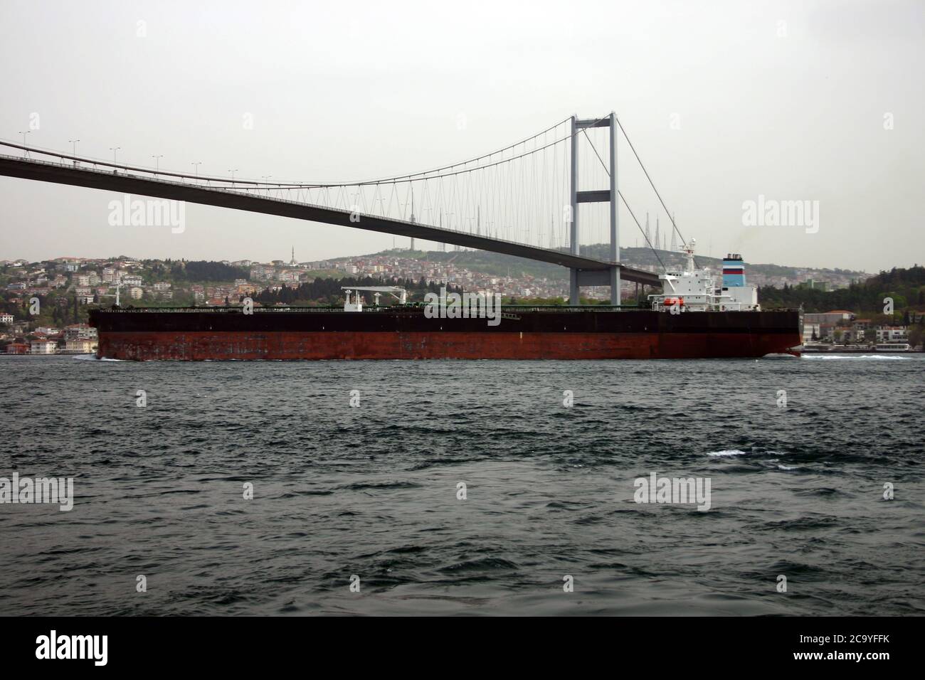A big oil tanker passing under the bridge in the Bosphorus. The ...
