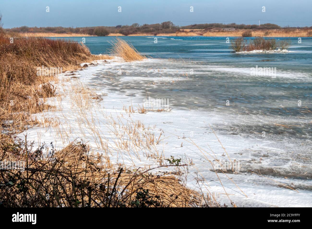 A lagoon at the RSPB Dungeness bird reserve covered in ice during ...