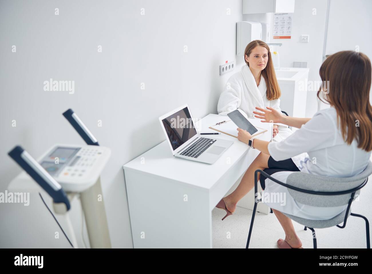Female beauty doctor talking with patient in beauty clinic Stock Photo ...