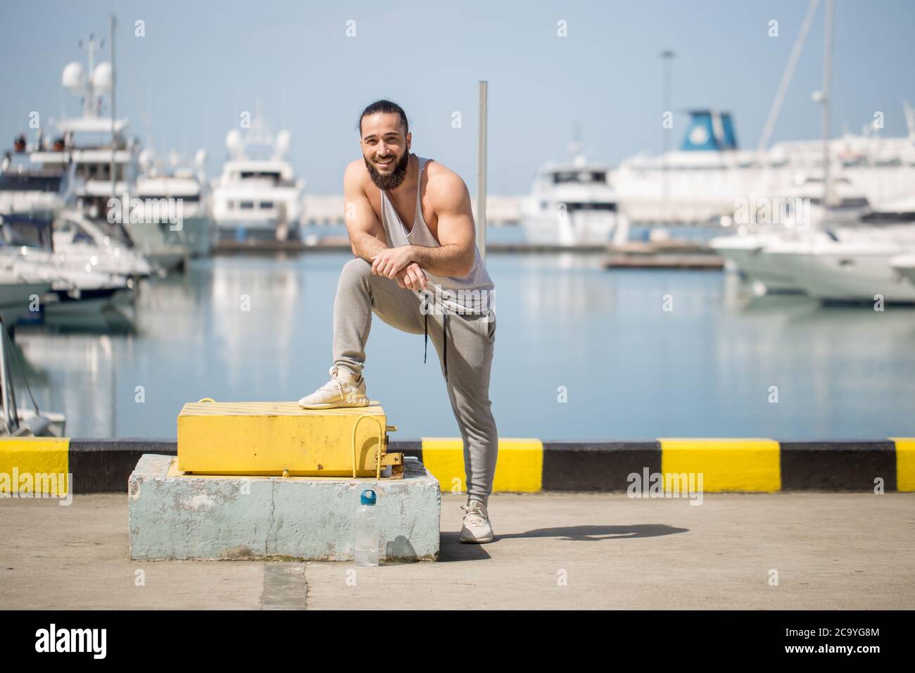 Athletic crossfit instructor relaxing after hard workout outdoors ...