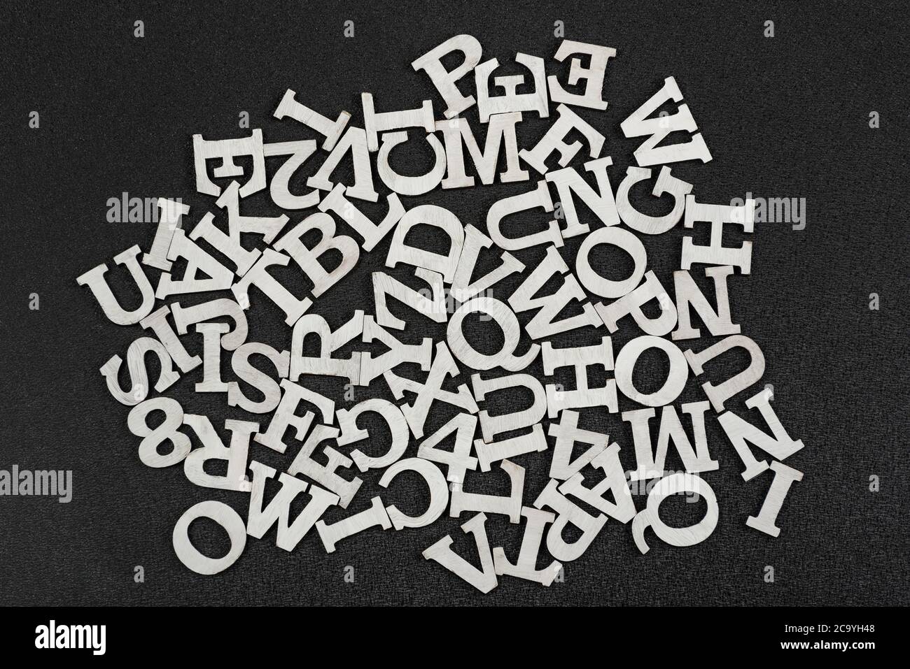 Letters of English alphabet arranged in chaotic order on black ...