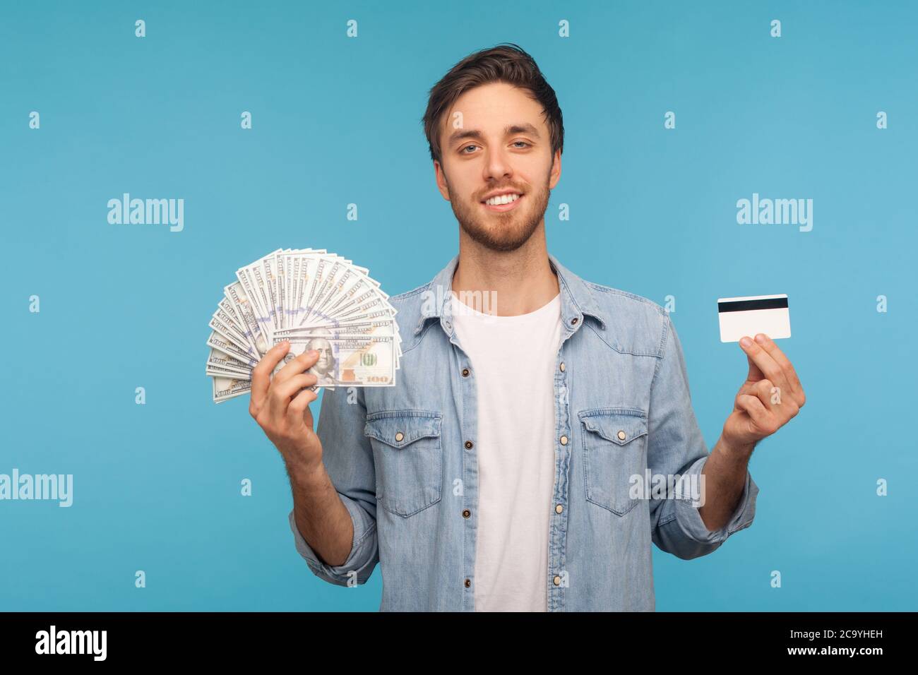 Money transfer. Portrait of happy handsome man in worker denim shirt ...