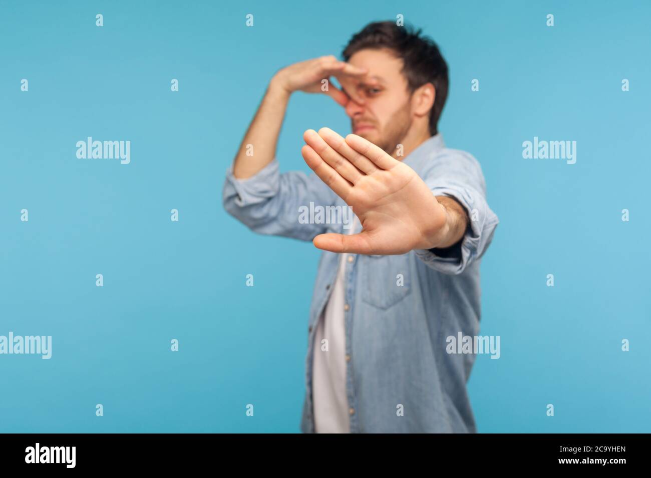 Stop this awful stink! Portrait of man in denim shirt grimacing in ...