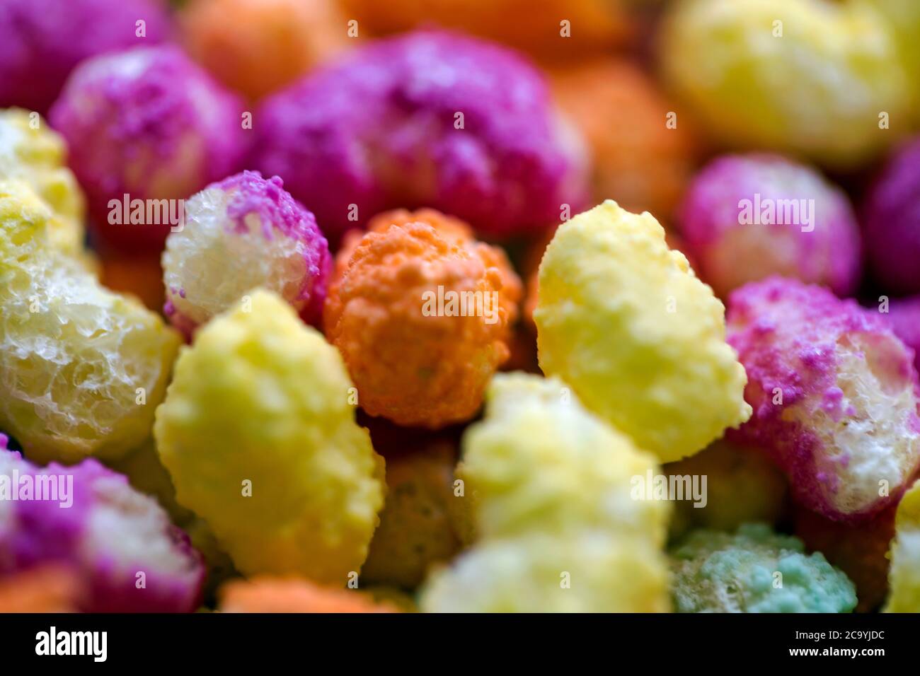 Brightly coloured grains of puffed rice shot close up in landscape ...