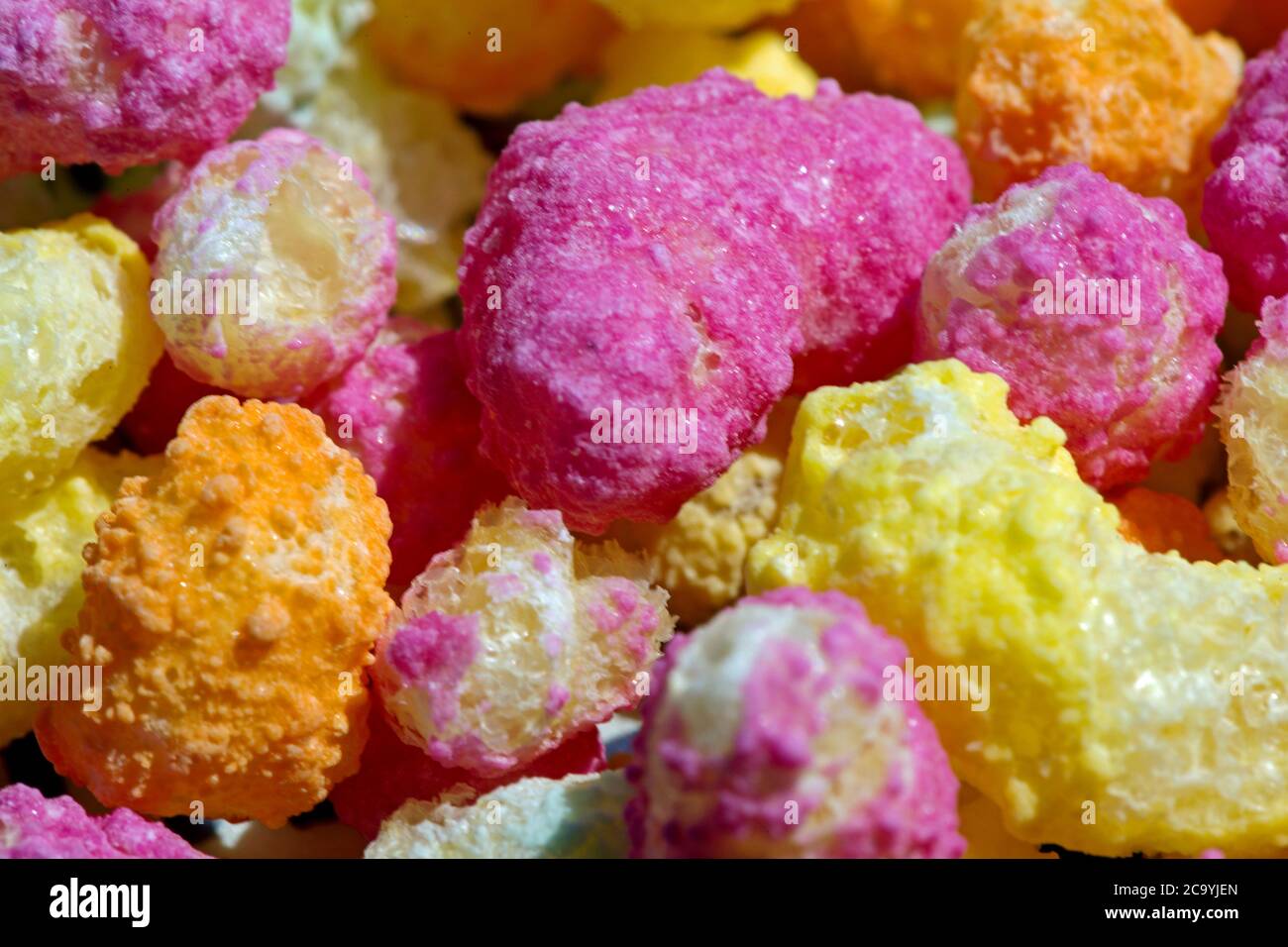 Brightly coloured grains of puffed rice shot close up in landscape ...