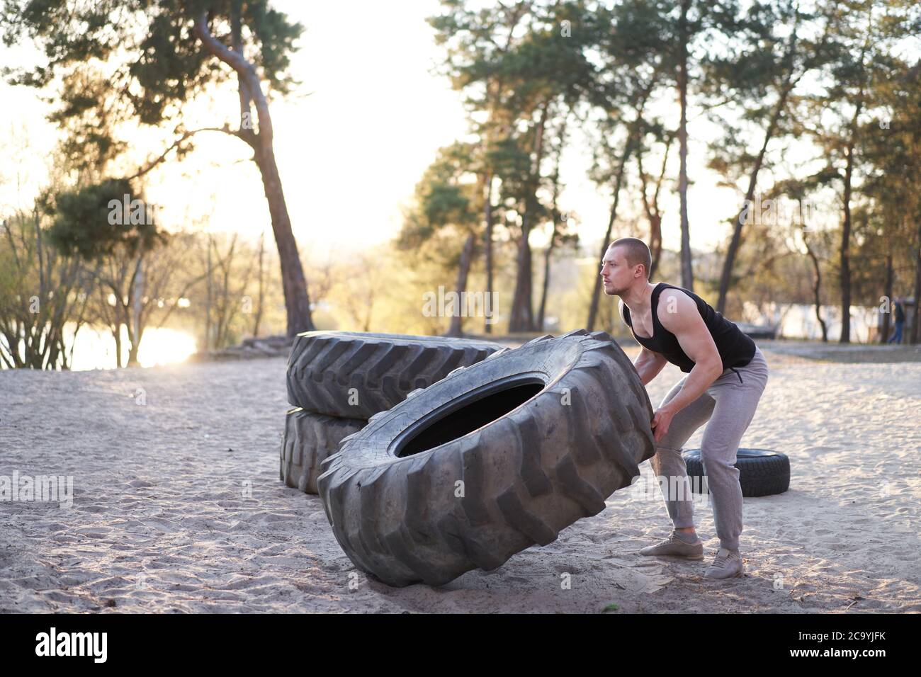 Strong man training workout lifting large tire outdoor DIY gym ...