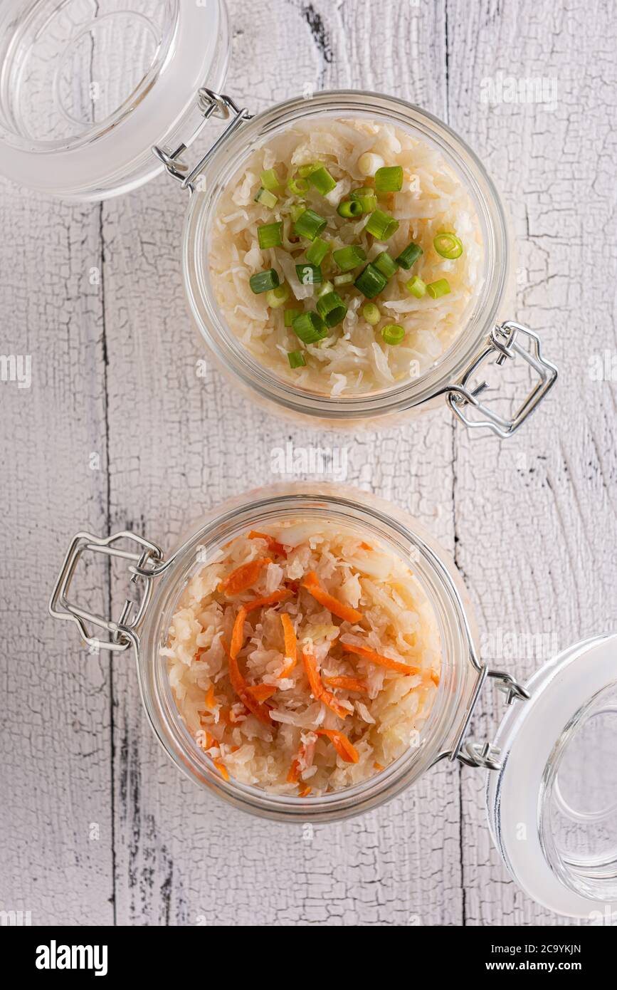 Two open glass jars full of homemade fermented cabbage with carrot and ...