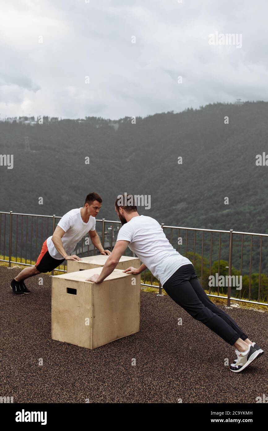 Cross-training of two male sports people in early summer morning in ...