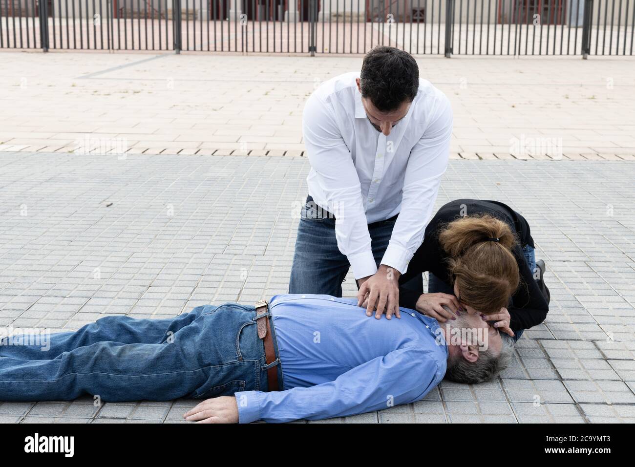 Passers helping an unconscious man outdoors - first aid concept Stock ...