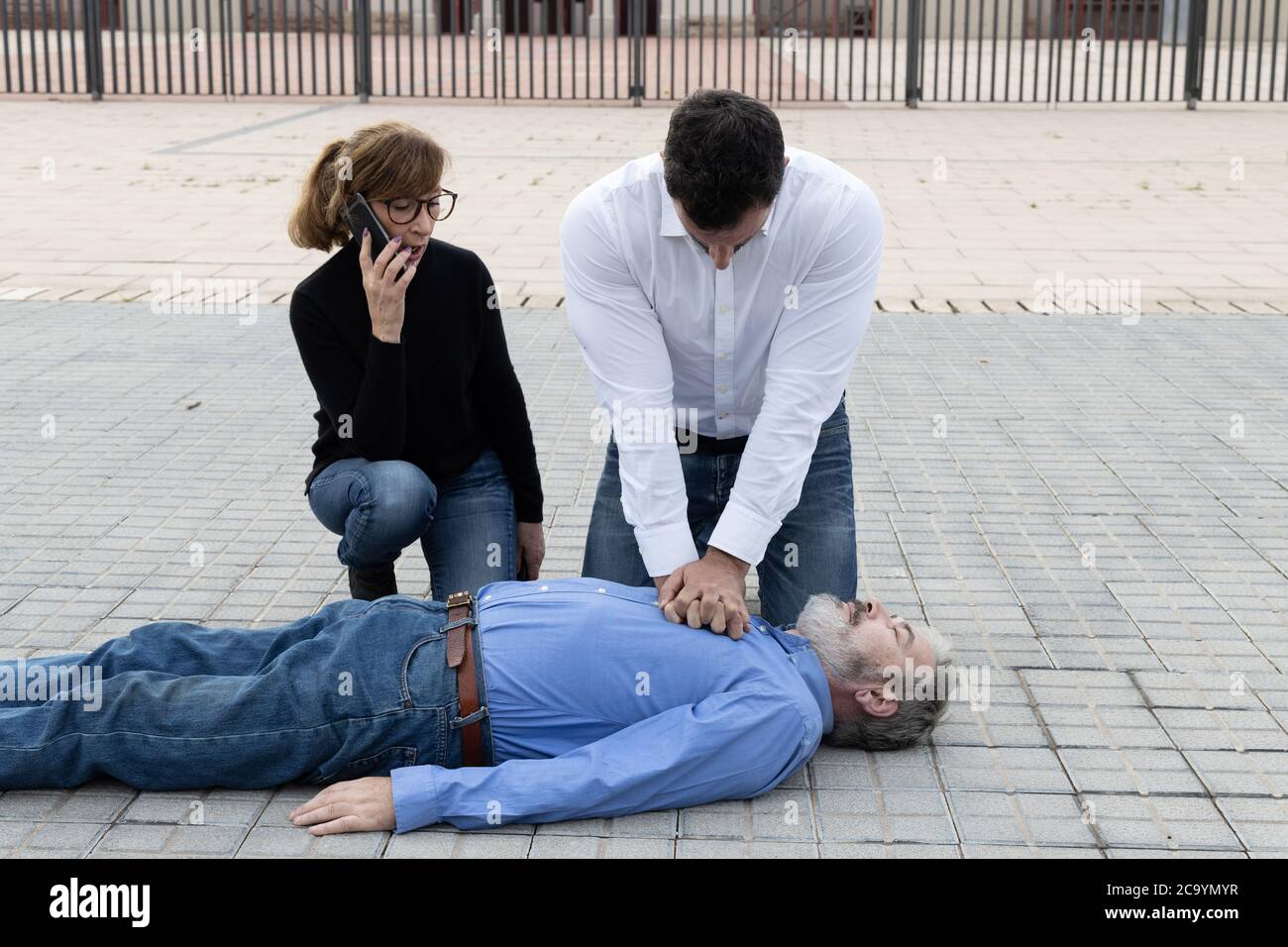 Passers helping an unconscious man outdoors - first aid concept Stock ...