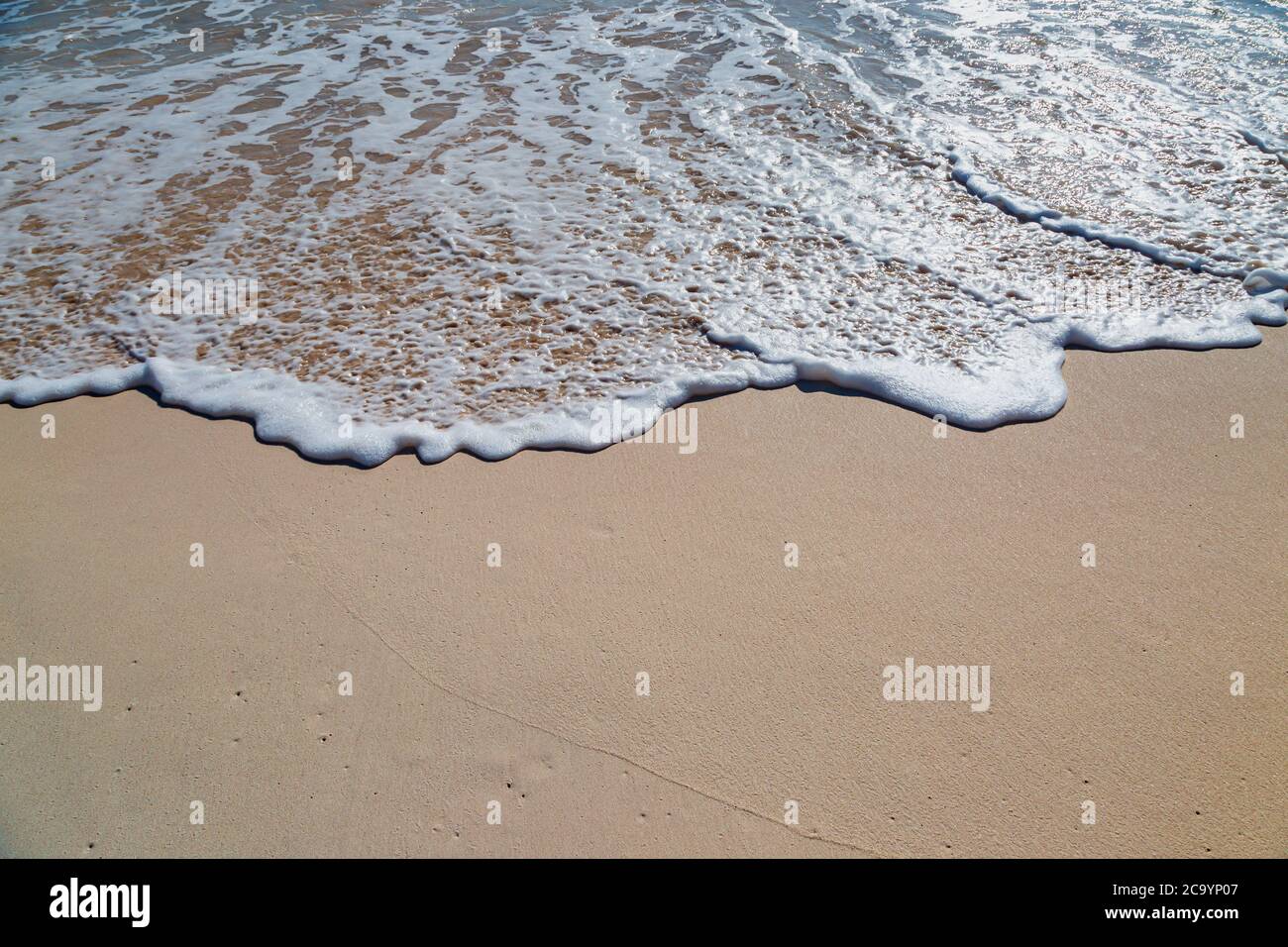 A full frame photograph of waves lapping a sandy beach Stock Photo - Alamy
