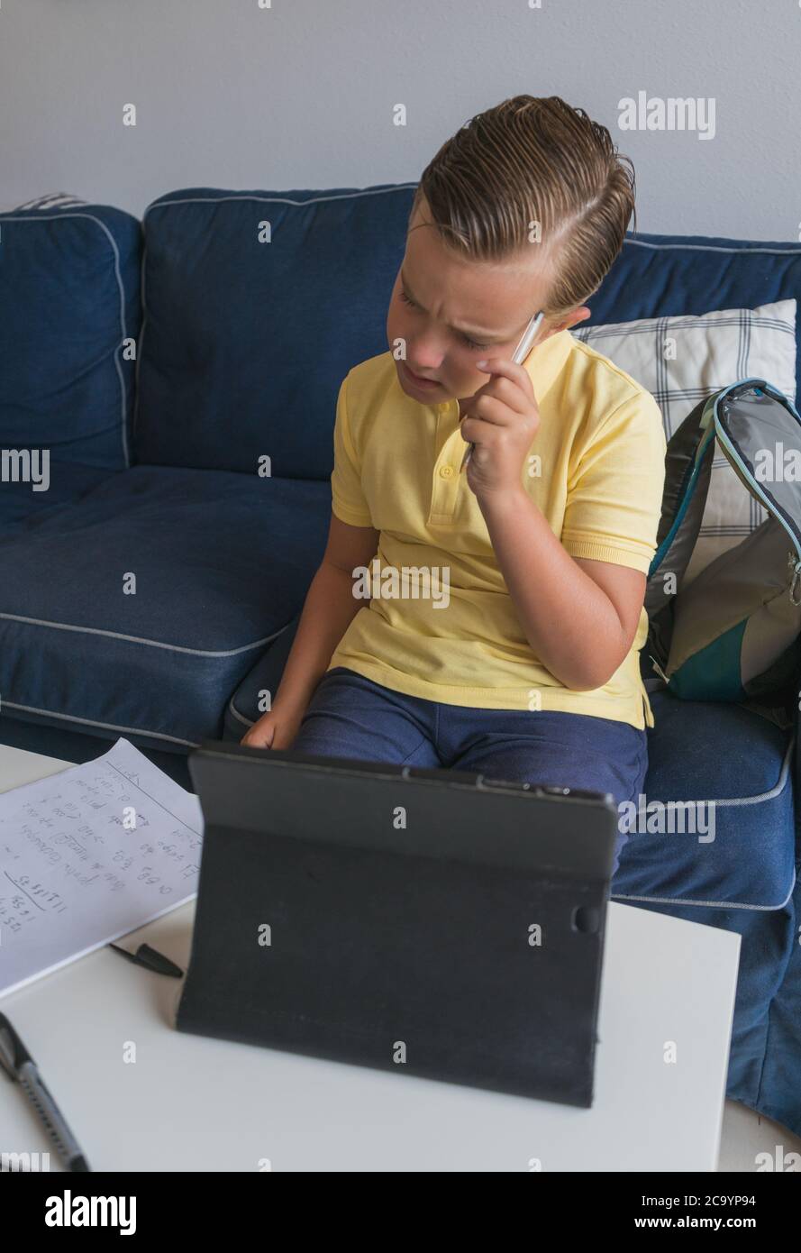 Young student boy thinking and tapping pencil on head and contemplating ...