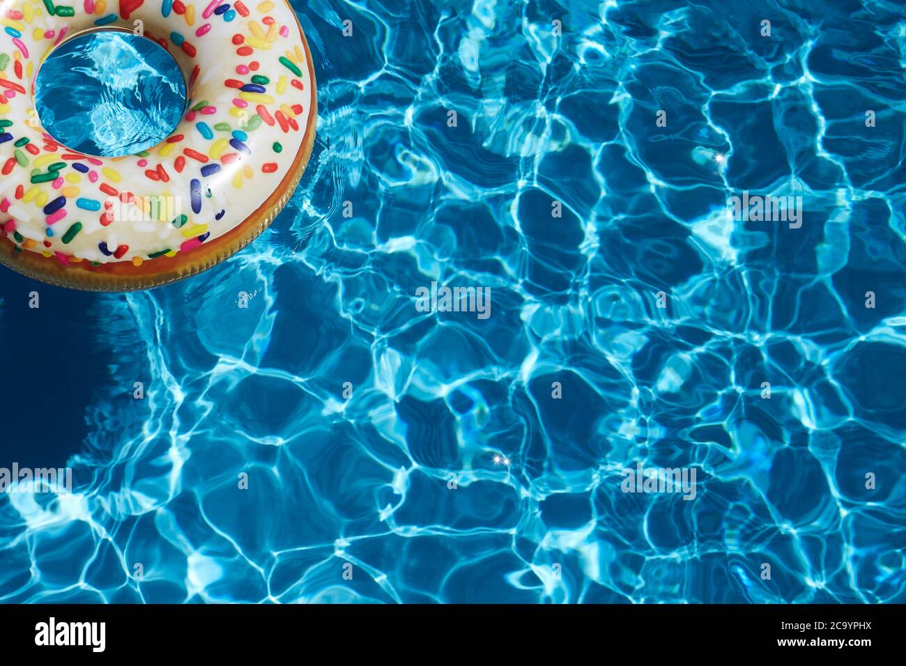 Inflatable donut ring in blue swimming pool, top view Stock Photo - Alamy