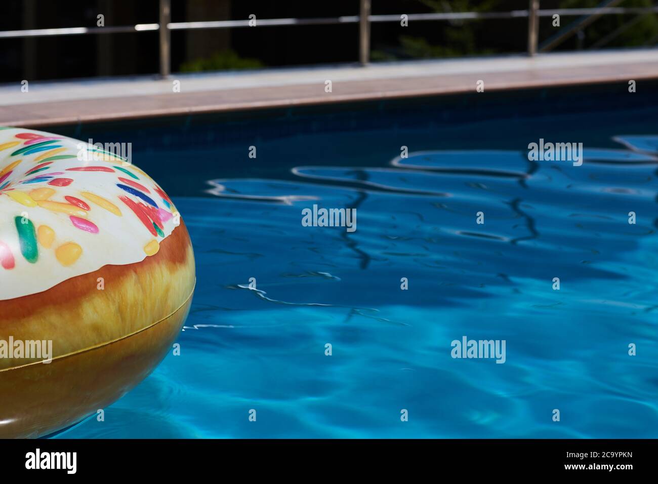 Inflatable donut ring in blue swimming pool, summer vacation concept ...