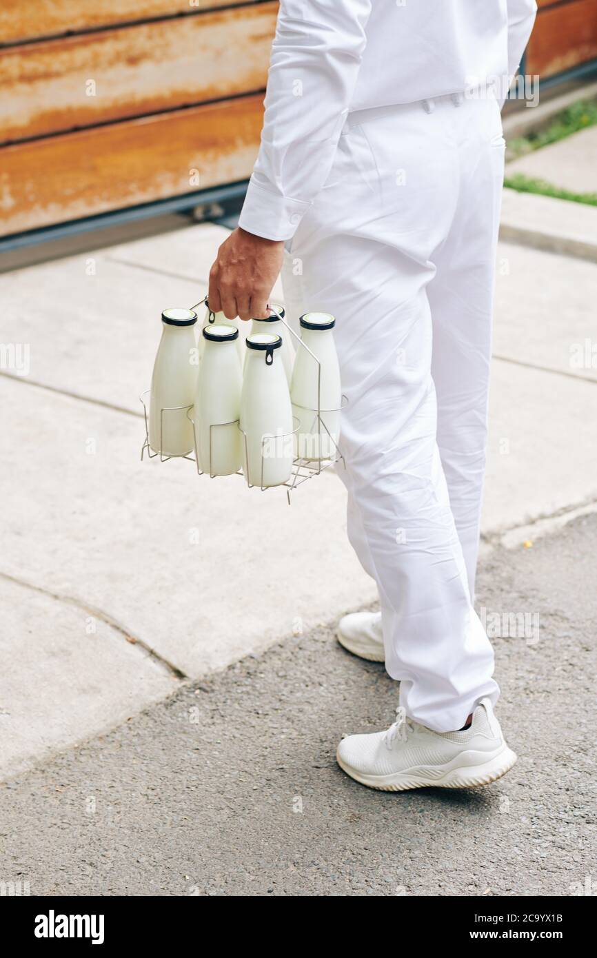 Delvery man carrying glass bottles to entrance of customer Stock Photo ...