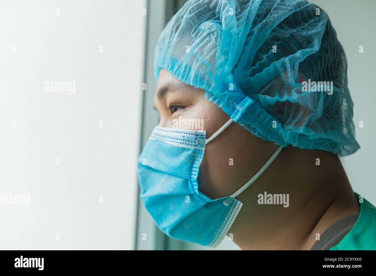 Tired doctor at the hospital looking through a window. The fight ...