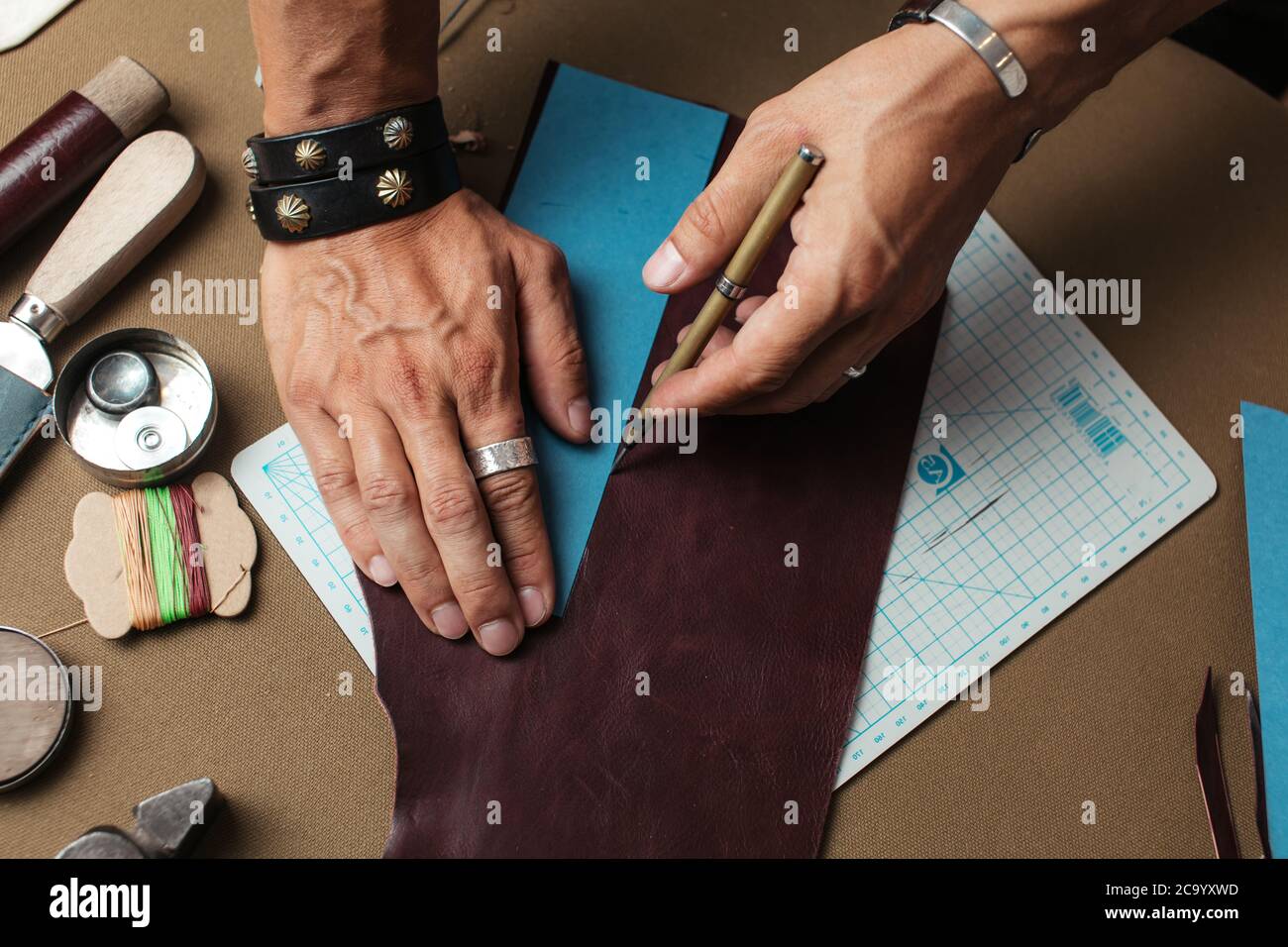 Closeup male hands working with leather using crafting DIY tools. Small ...