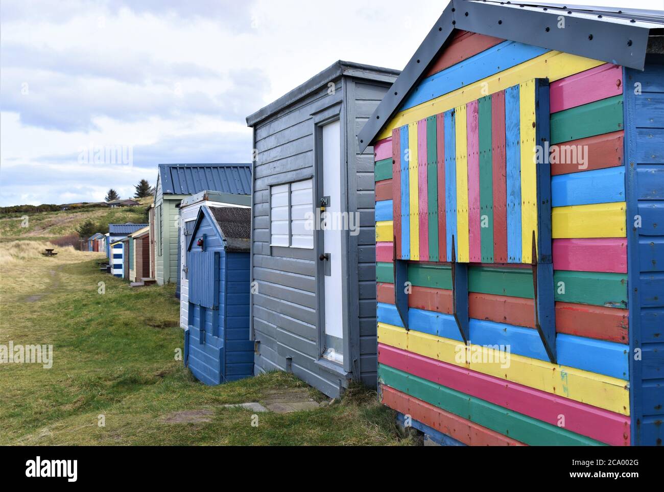 A row of painted beach huts on Hopeman Beach on the Moray Firth in ...