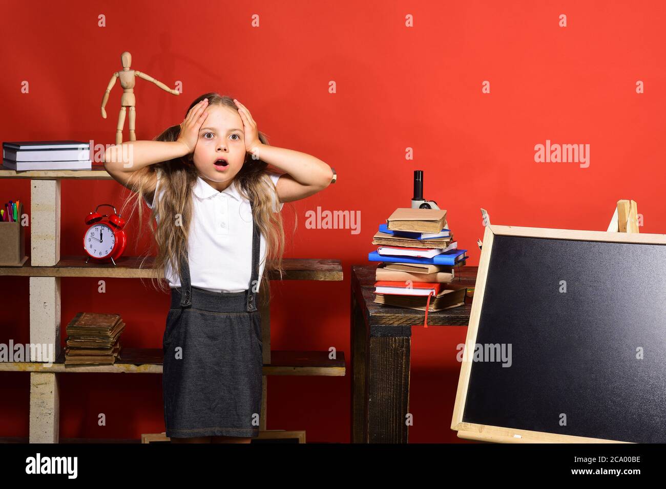 Schoolgirl with frightened face in her classroom. Kid and school ...