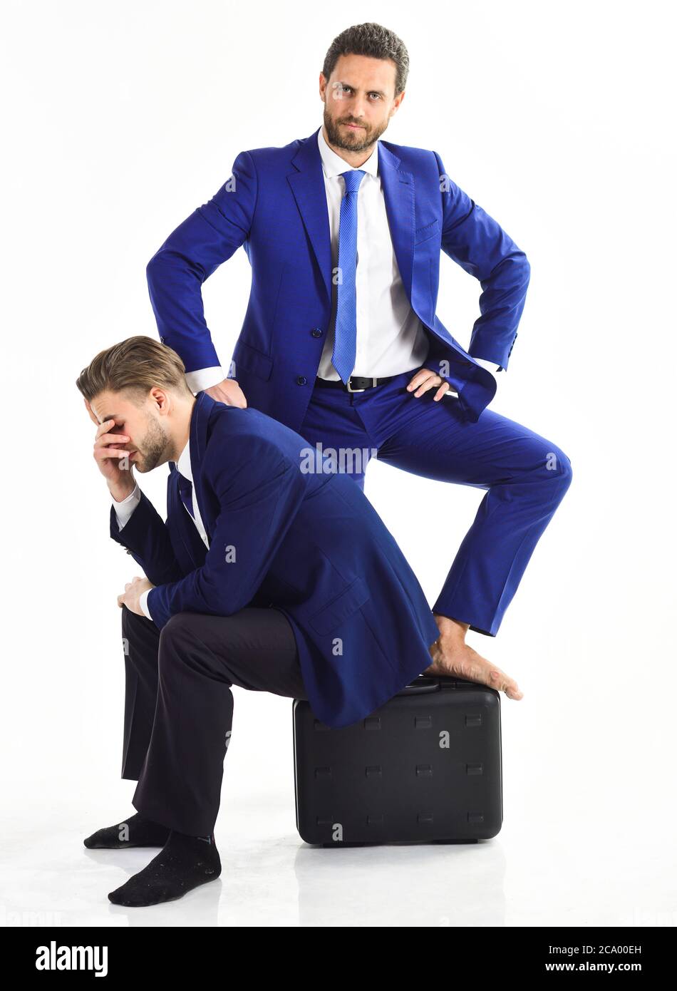 Man in suit or businessman sit on briefcase with desperate expression ...
