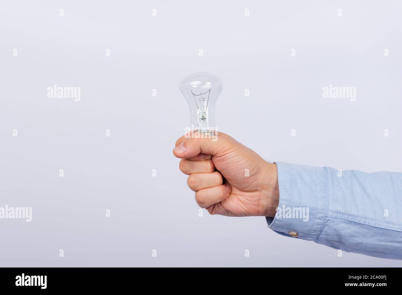 Incandescent bulb in male hand on white background. Side view Stock ...