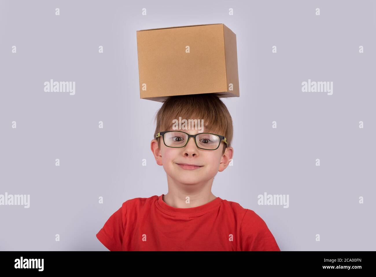 Cardboard box on head of boy. Child holding box on his head Stock Photo ...